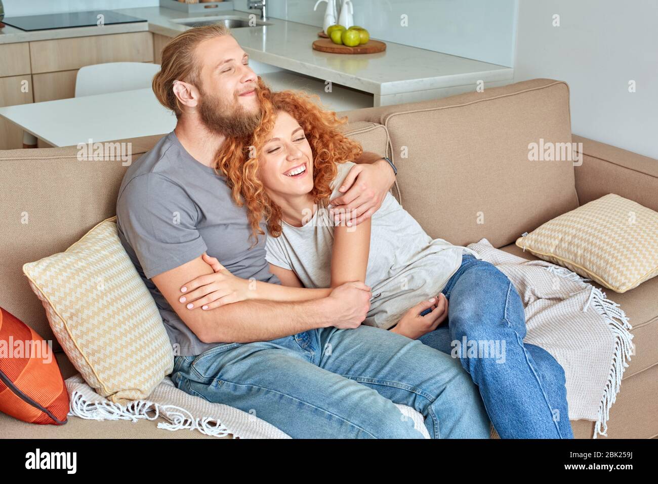 Relationship Concept. Couple sitting on sofa at living room hugging ...