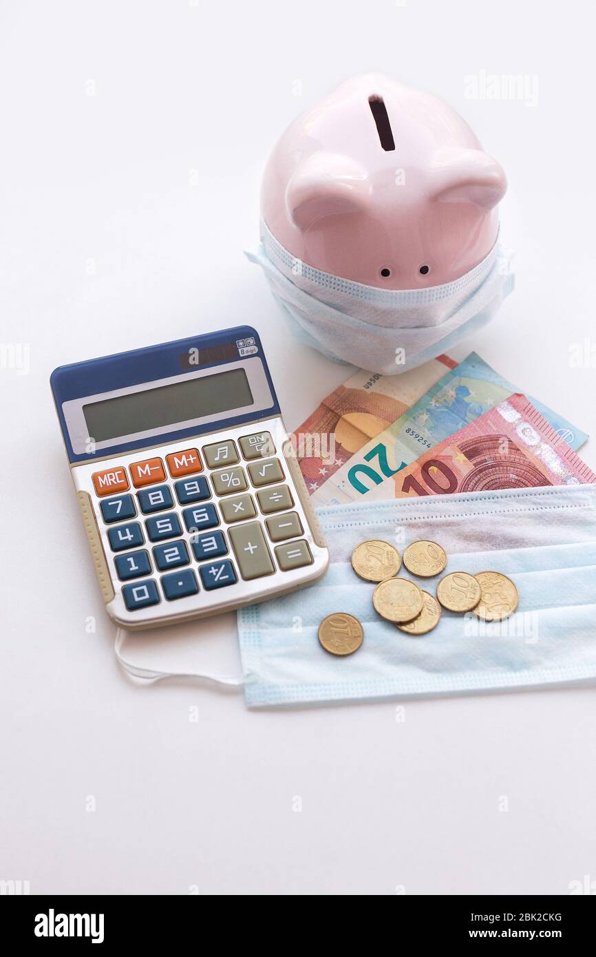 piggy bank wearing protective face mask with euro money on white ...