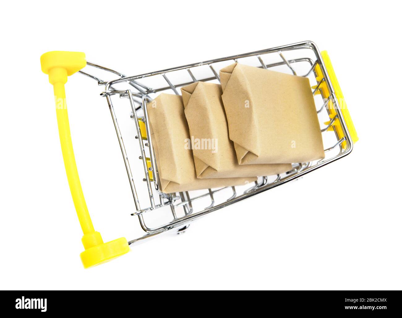 Top view on a miniature shopping cart with three small packages inside ...