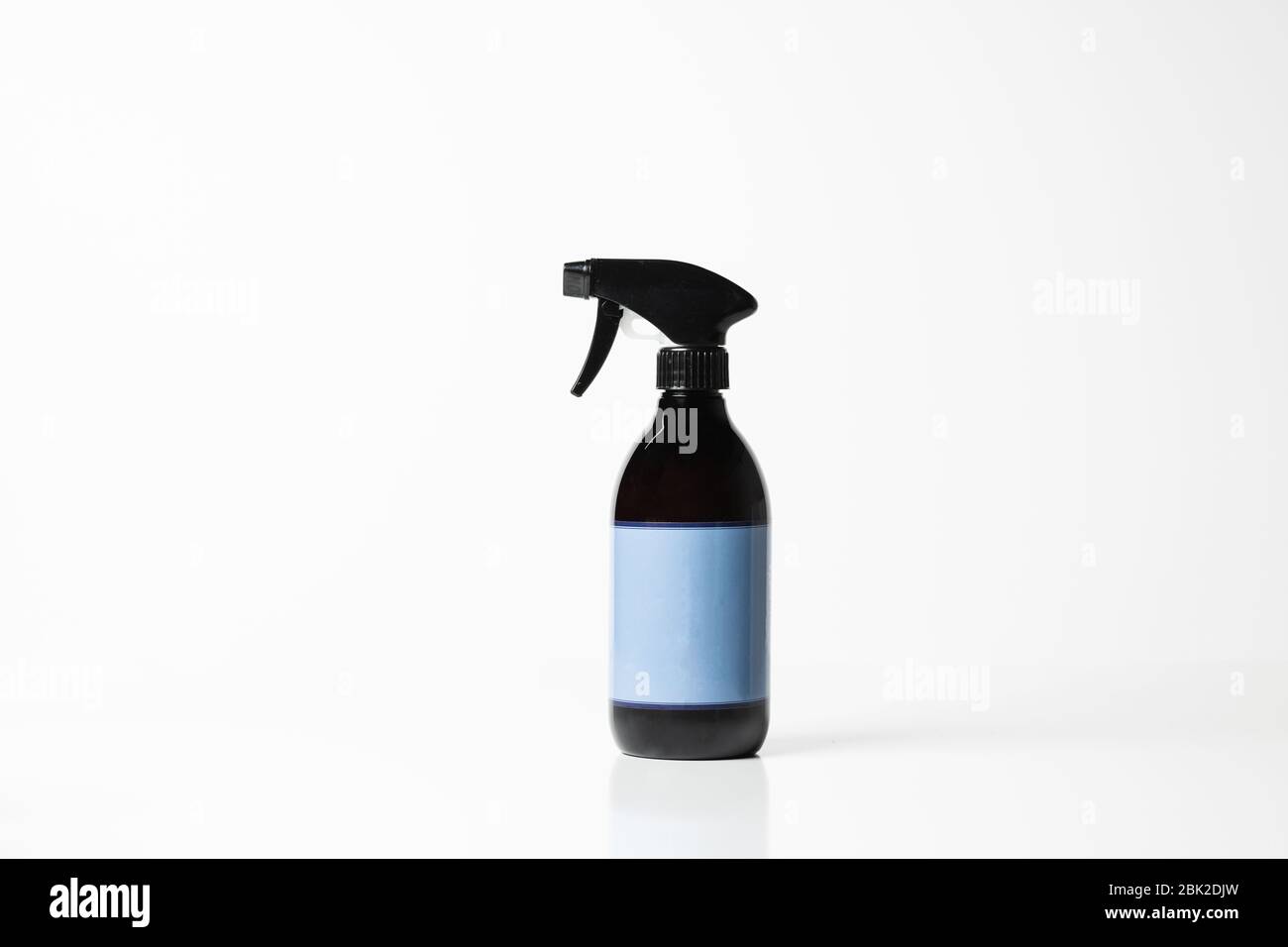 Black plastic bottle with trigger-spray and color label on a white ...