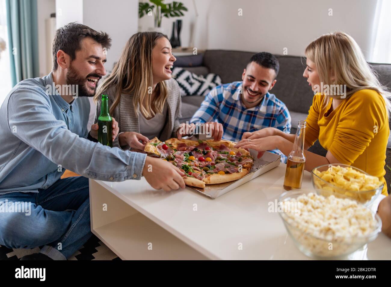 Friends having fun at party with delicious pizza.People sharing pizza ...