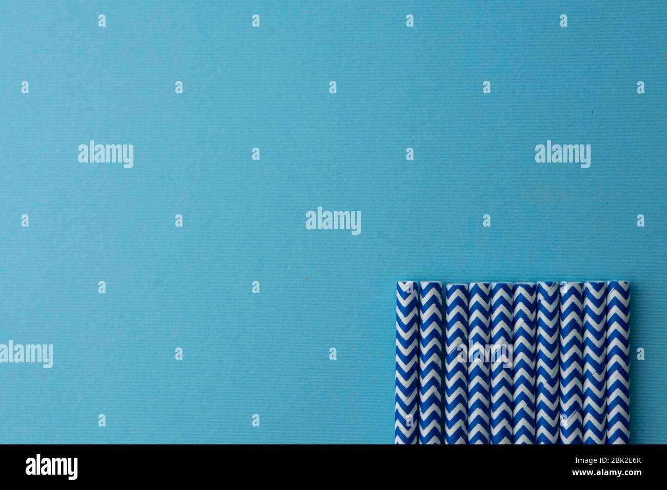 paper blue tubes for cocktails and drinks, copyspace, on a blue ...