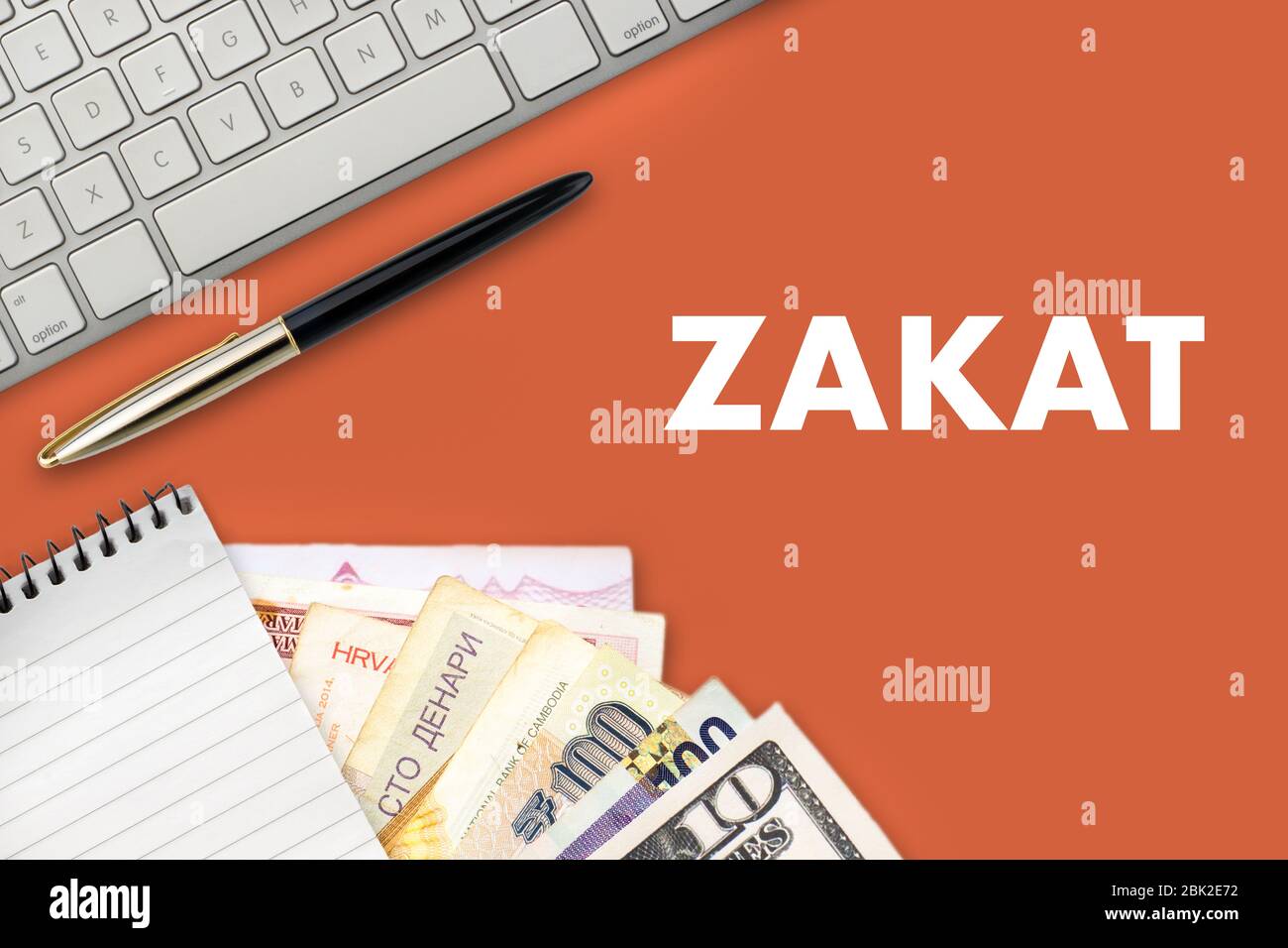 ZAKAT (islamic tax) text with notepad, keyboard, multi banknote or ...