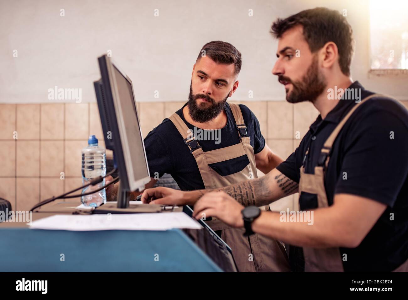 Two modern mechanics work in repair service.Teamwork concept Stock ...