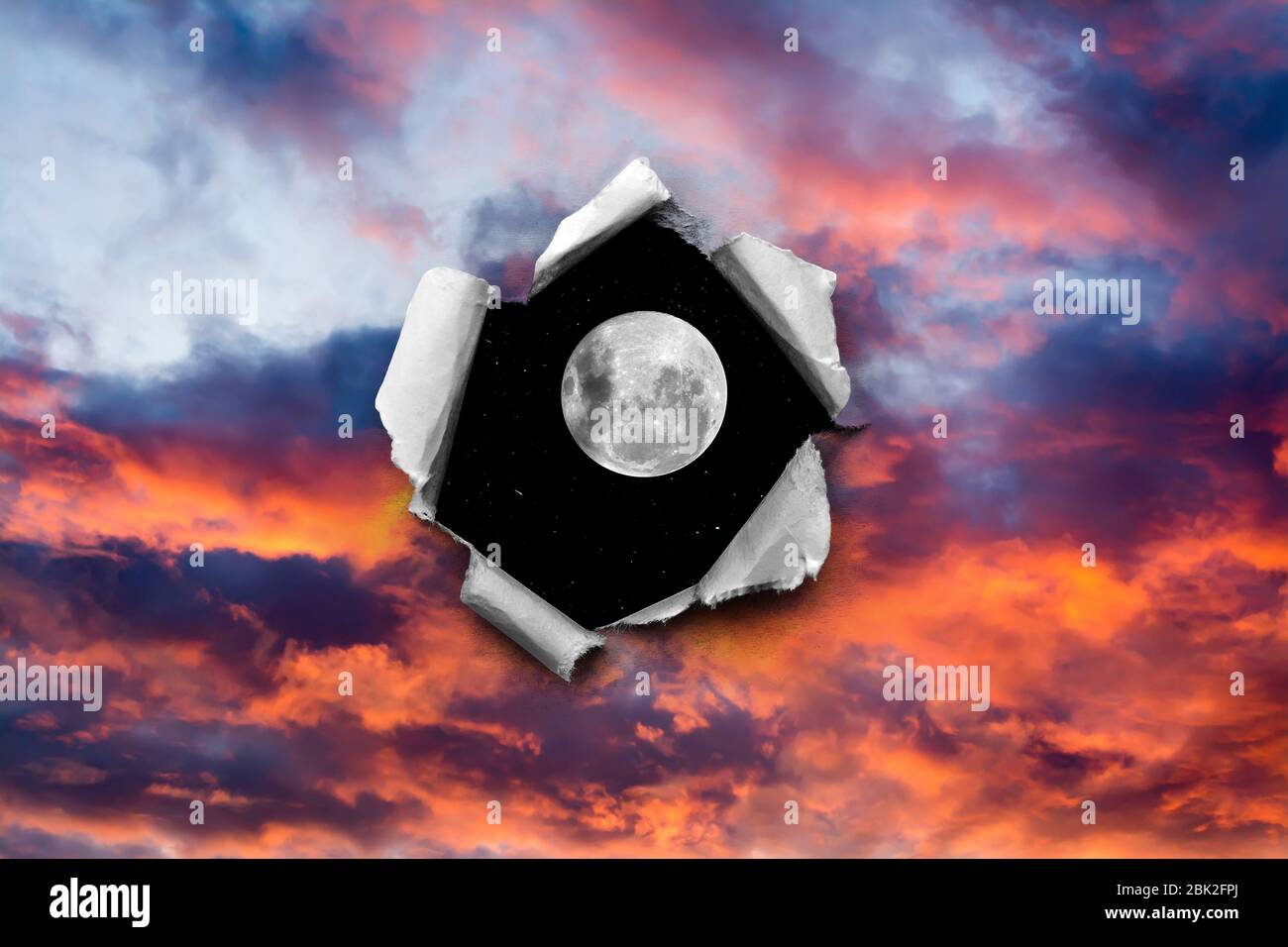 A hole in the sunset sky with torn edges, as if on paper, overlooking ...