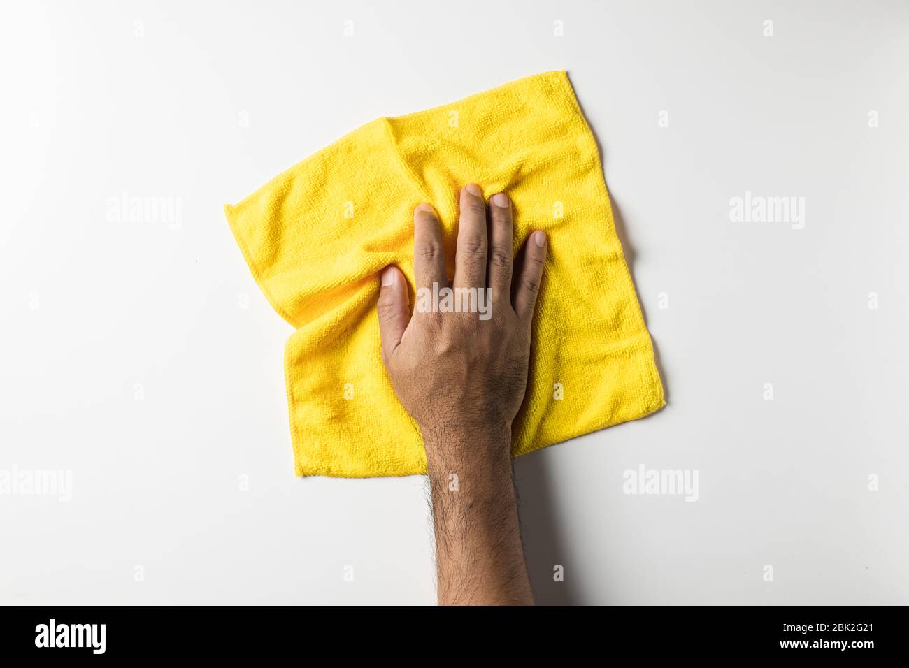 top view of hand with yellow cleaning rag isolated on white background ...