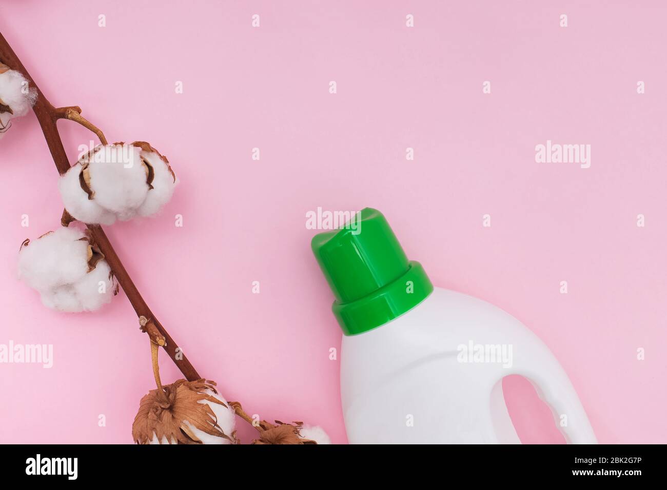 Liquid washing detergent and cotton flowers on pink background Stock ...