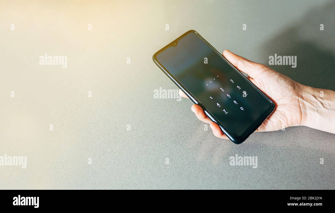 Mobile phone held in one hand and showing the lock screen Stock Photo ...
