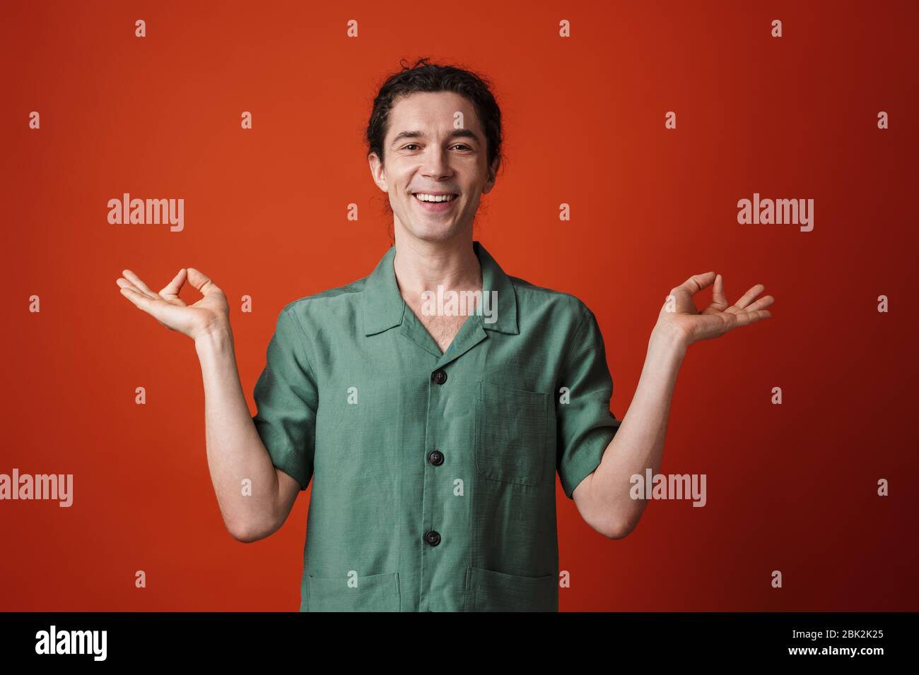 Image of joyful handsome man smiling and making zen gesture isolated ...