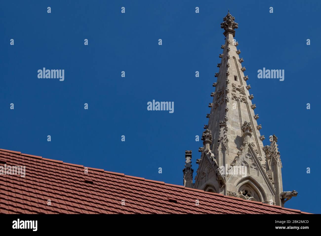 Diagonal line of a new red roof. Top of a slim stone tower of St ...