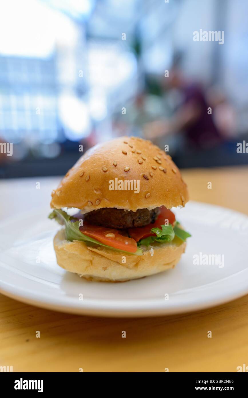 Portrait of small hamburger in bite size on plate Stock Photo - Alamy