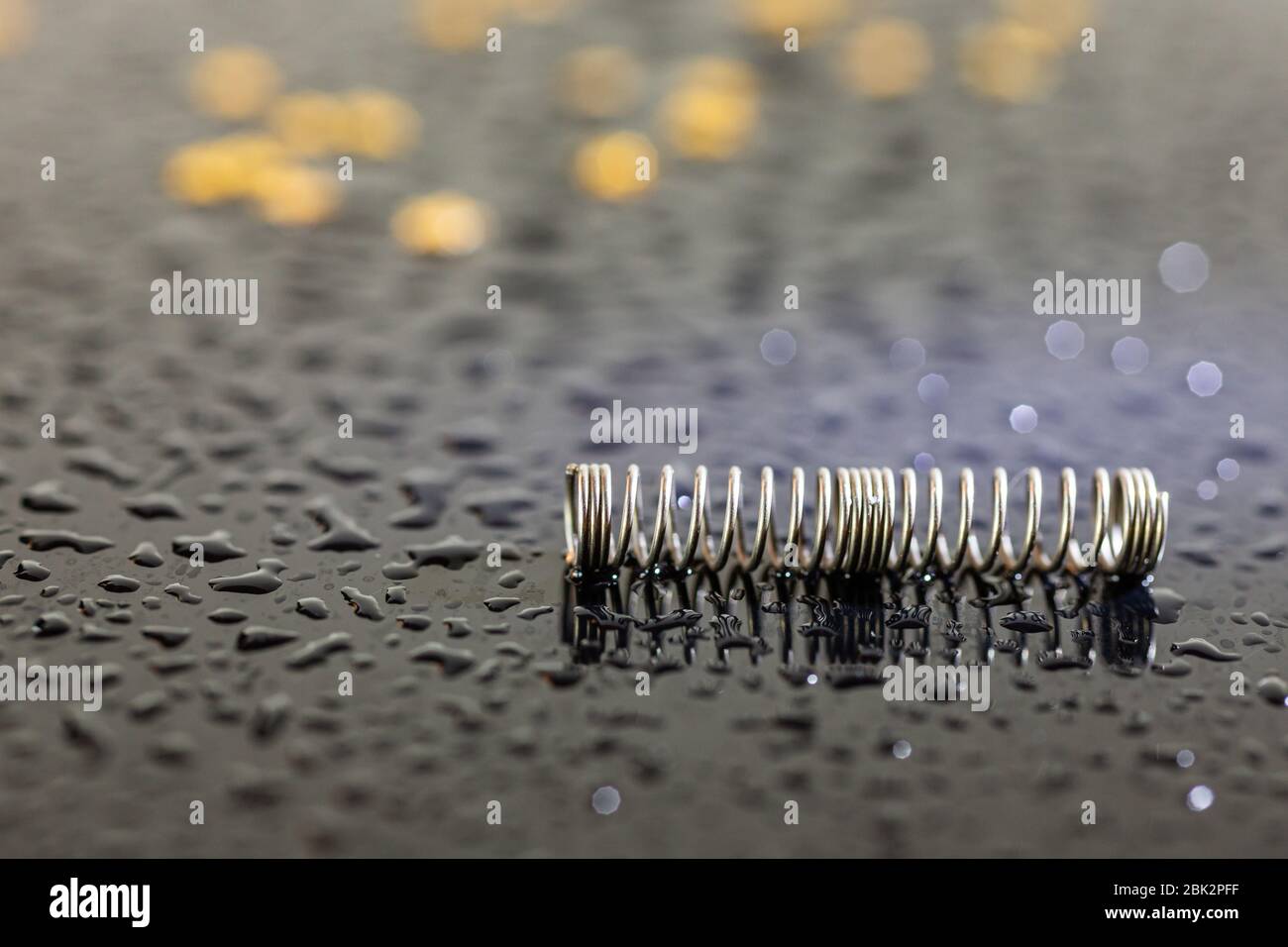 Metal spring on a black background. Precision mechanics. Small items ...