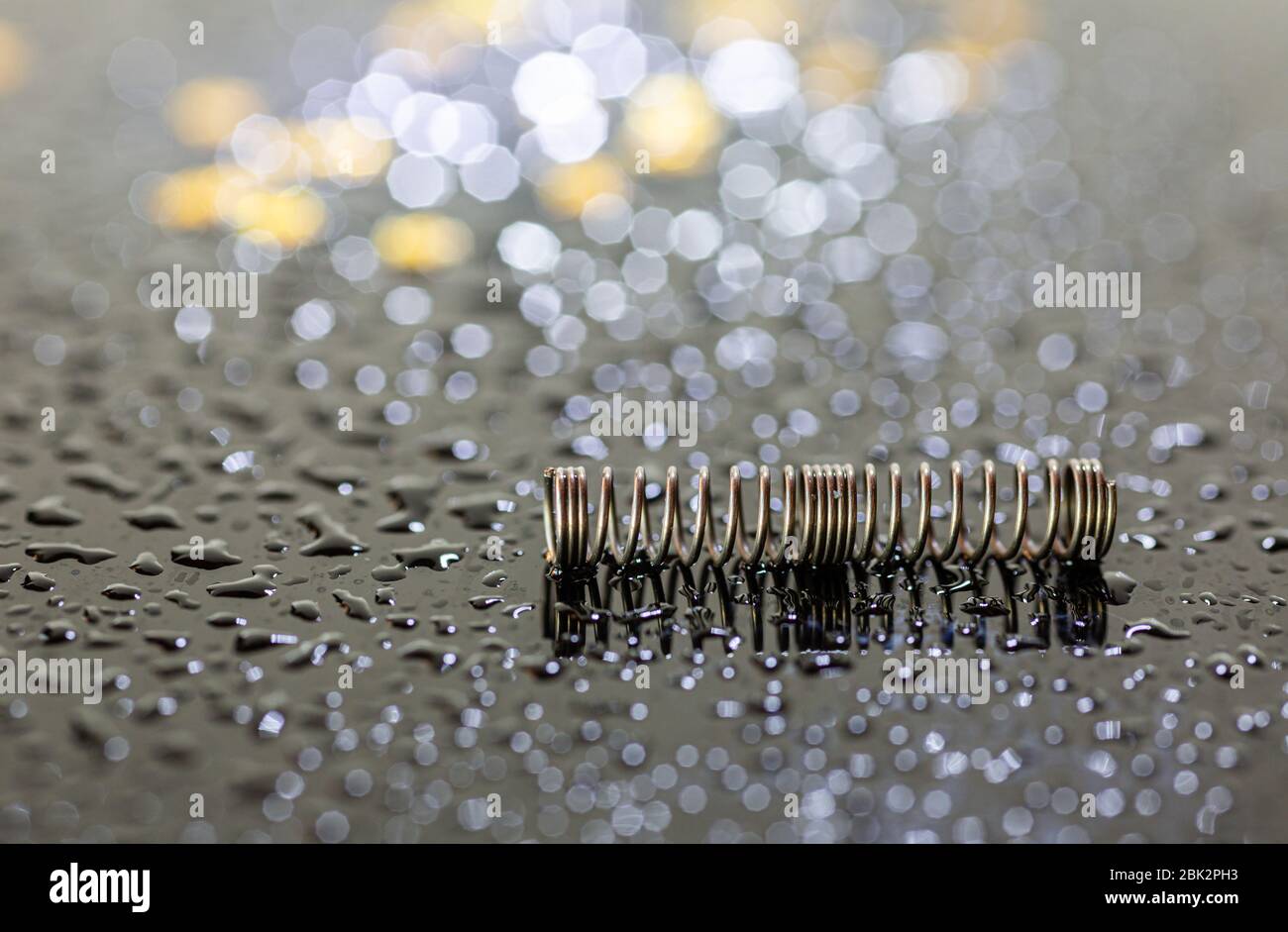 Metal spring on a black background. Precision mechanics. Small items ...