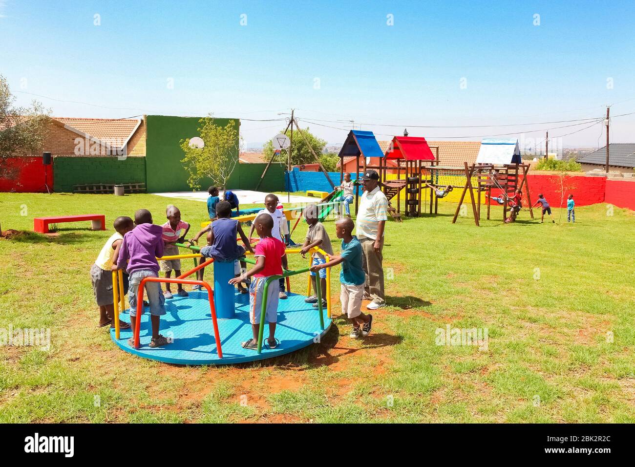 Soweto, South Africa - December 11, 2010: African kids playing merry go ...
