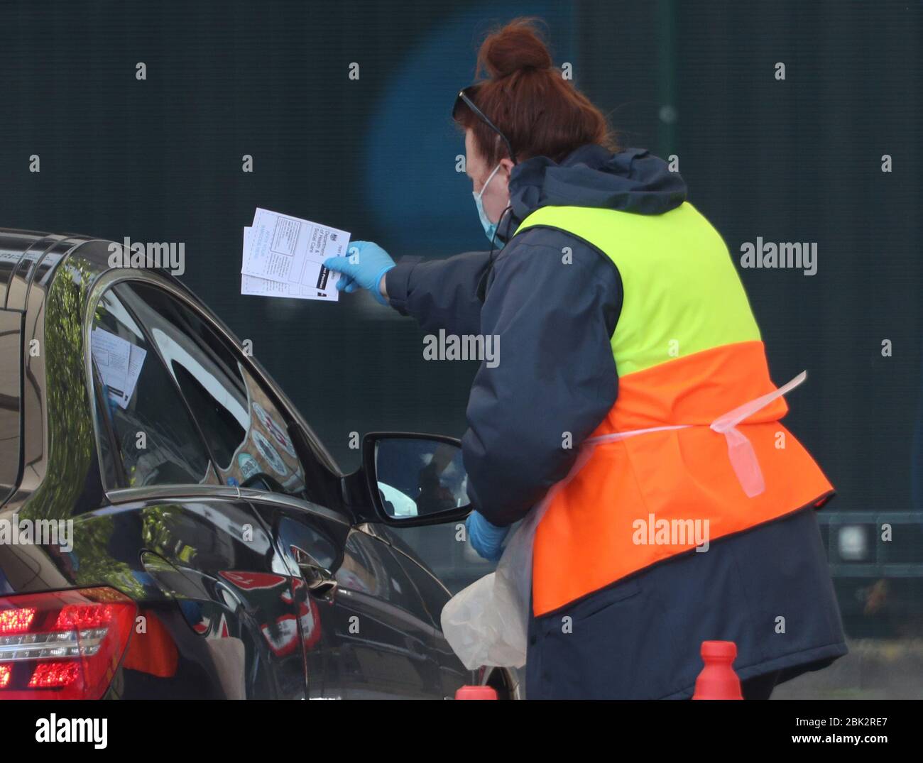 Staff hand over paper work at a drive-thru coronavirus testing station ...