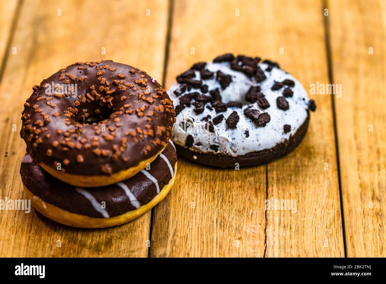 Colorful donuts on wooden table. Sweet icing sugar food with glazed ...