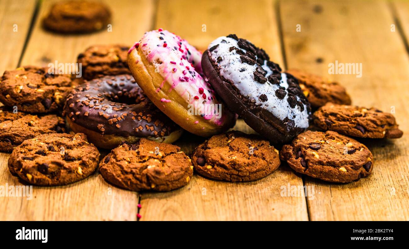 Colorful donuts on wooden table. Sweet icing sugar food with glazed ...
