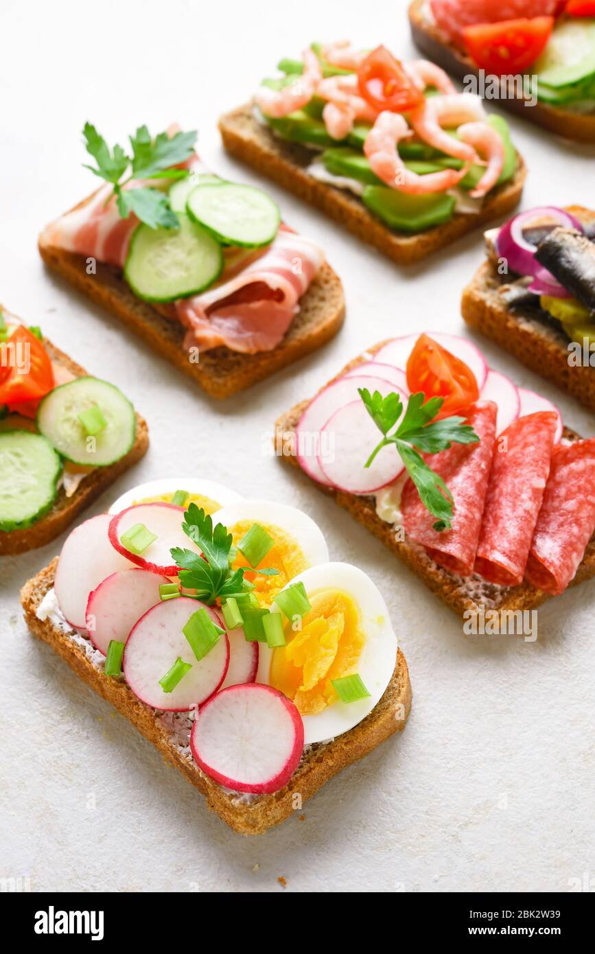 Assortment open sandwiches on light stone background. Tasty healthy ...