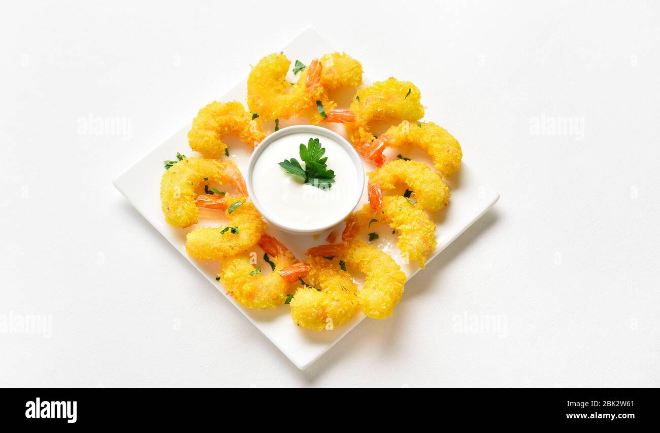 Deep fried breaded prawn on white plate over light stone background ...