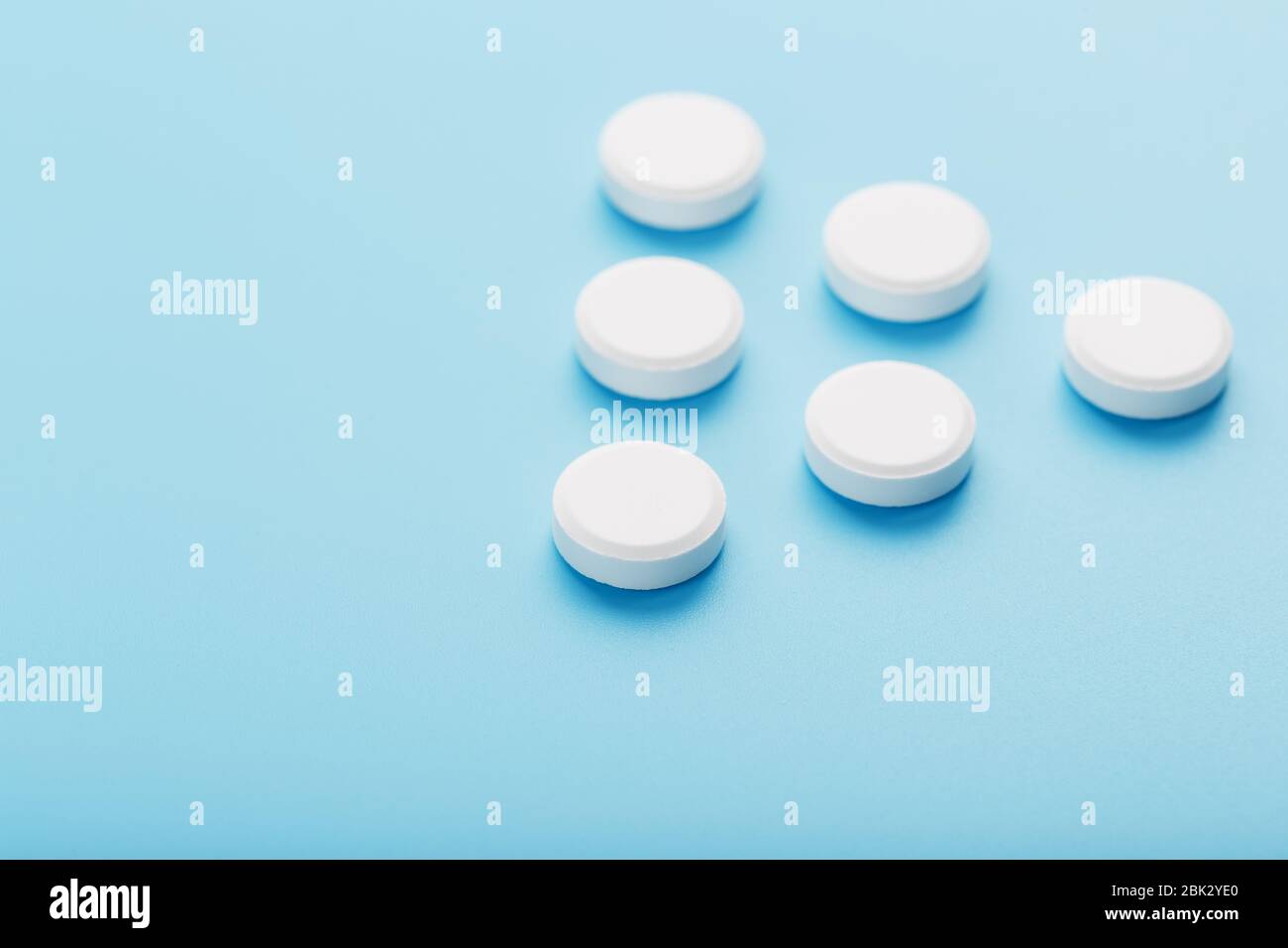 White medicinal tablets in the shape of a pyramid on a blue background ...