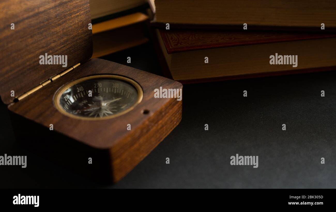 old compass close up with books Stock Photo - Alamy