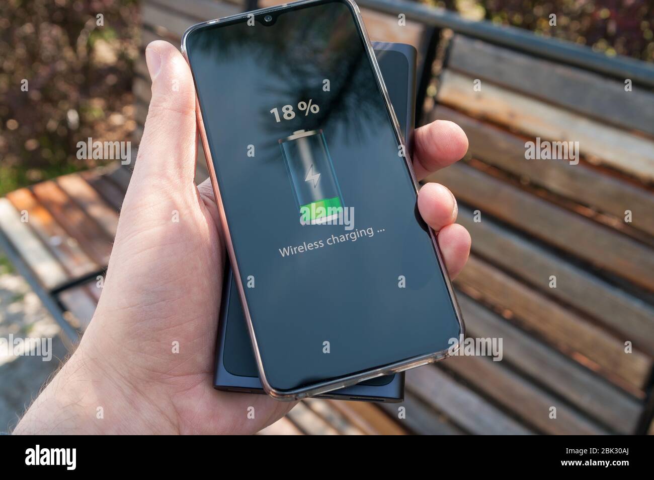 Smartphone charging without cable from induction power bank in the male ...