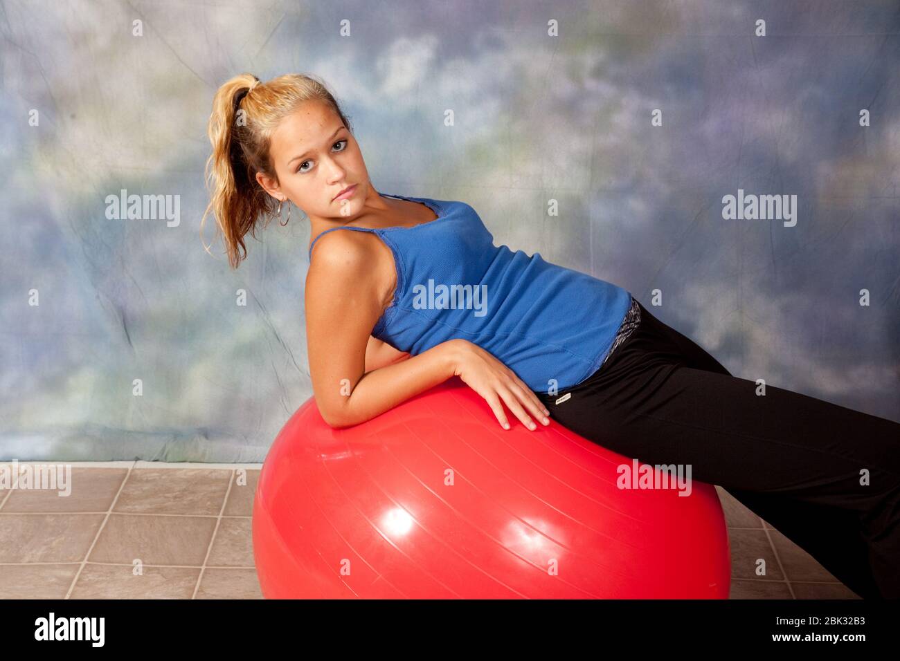 Blond girl on a red exercise ball Stock Photo - Alamy