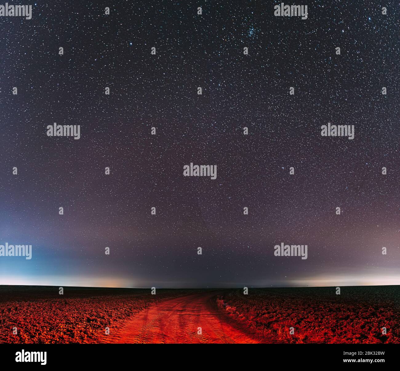 Night Starry Sky With Glowing Stars Above Country Road Is Lit In Red ...