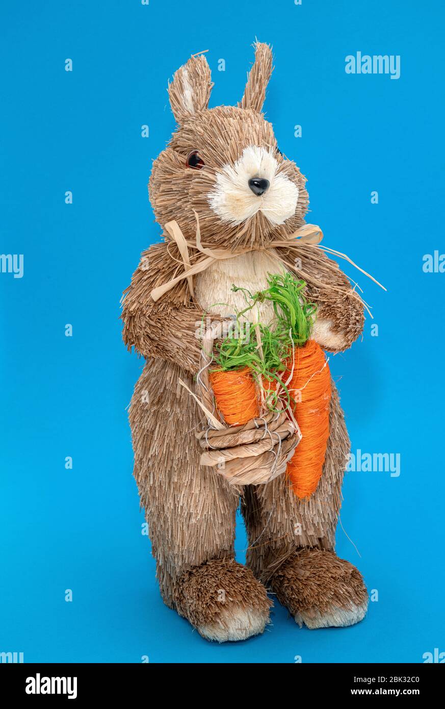 Straw Easter bunny - blue background Stock Photo - Alamy
