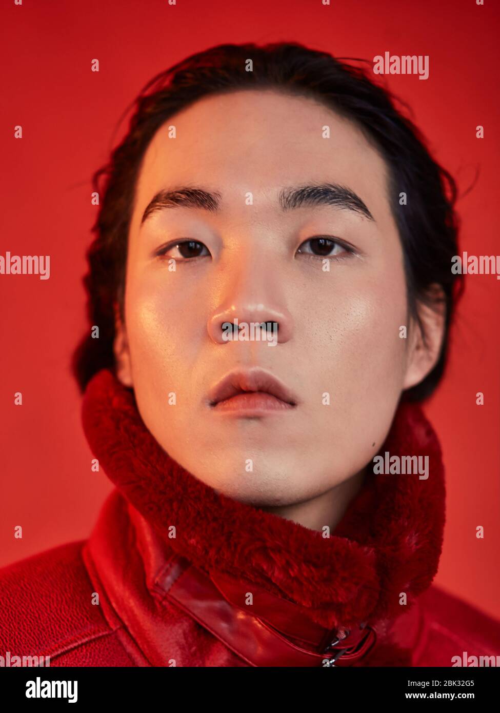 Asian man in red clothes on a red background Stock Photo - Alamy