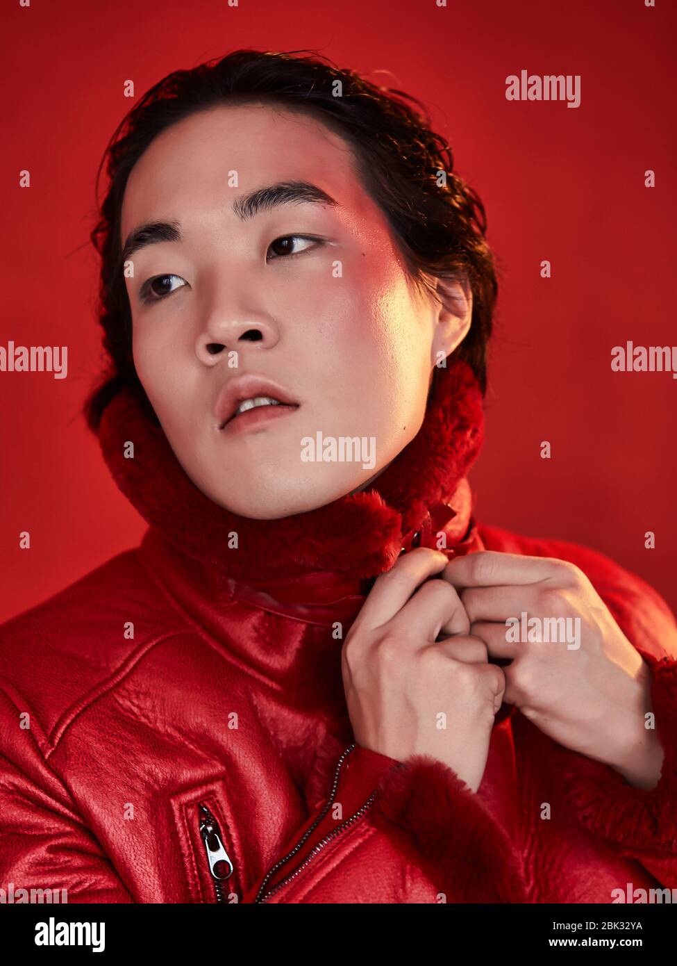Asian man in red clothes on a red background Stock Photo - Alamy