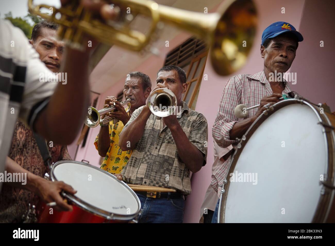 Villagers playing brass instruments and drums during a rural orchestra ...