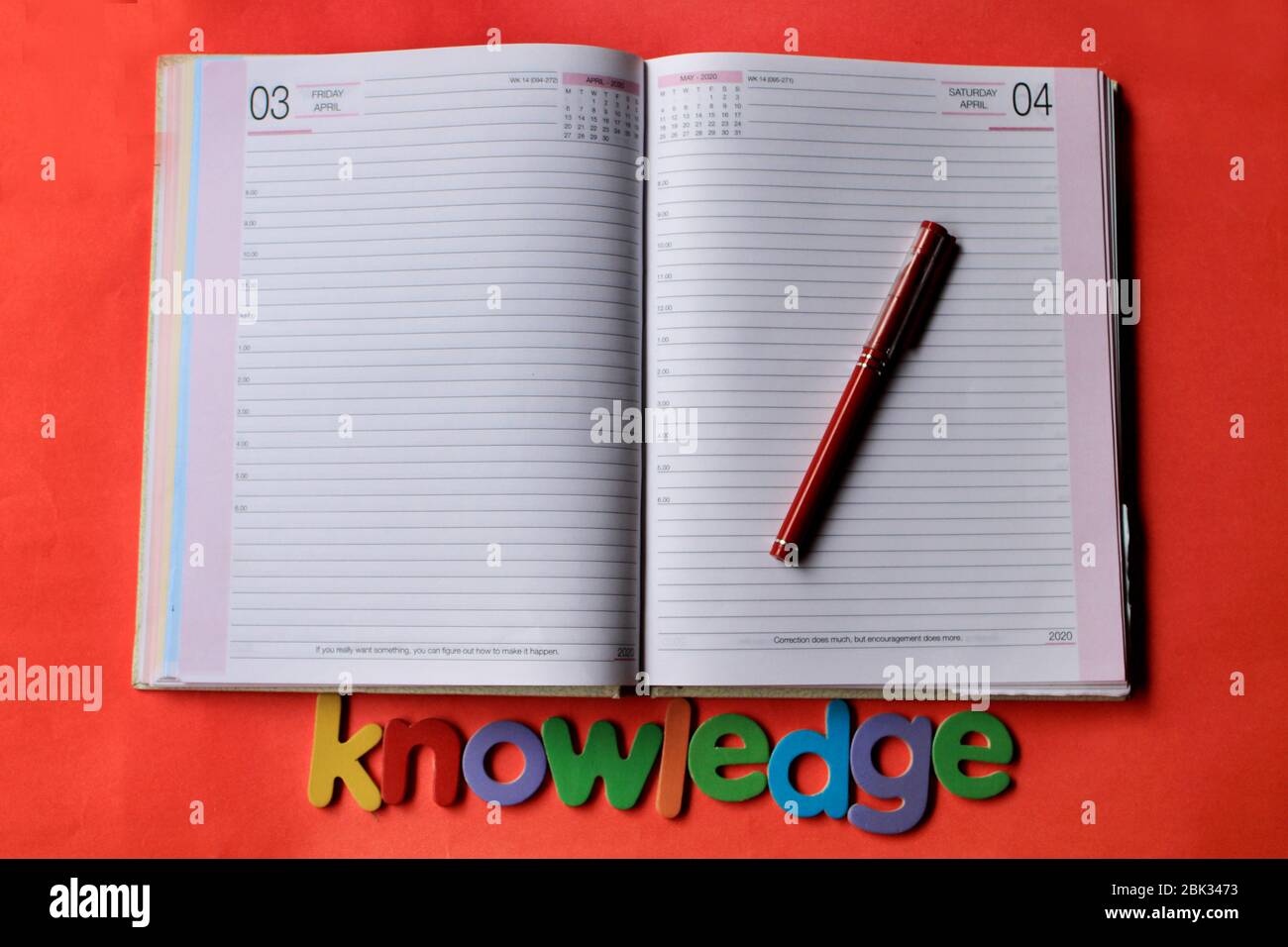 The word knowledge written on red background with Diary page and pen ...