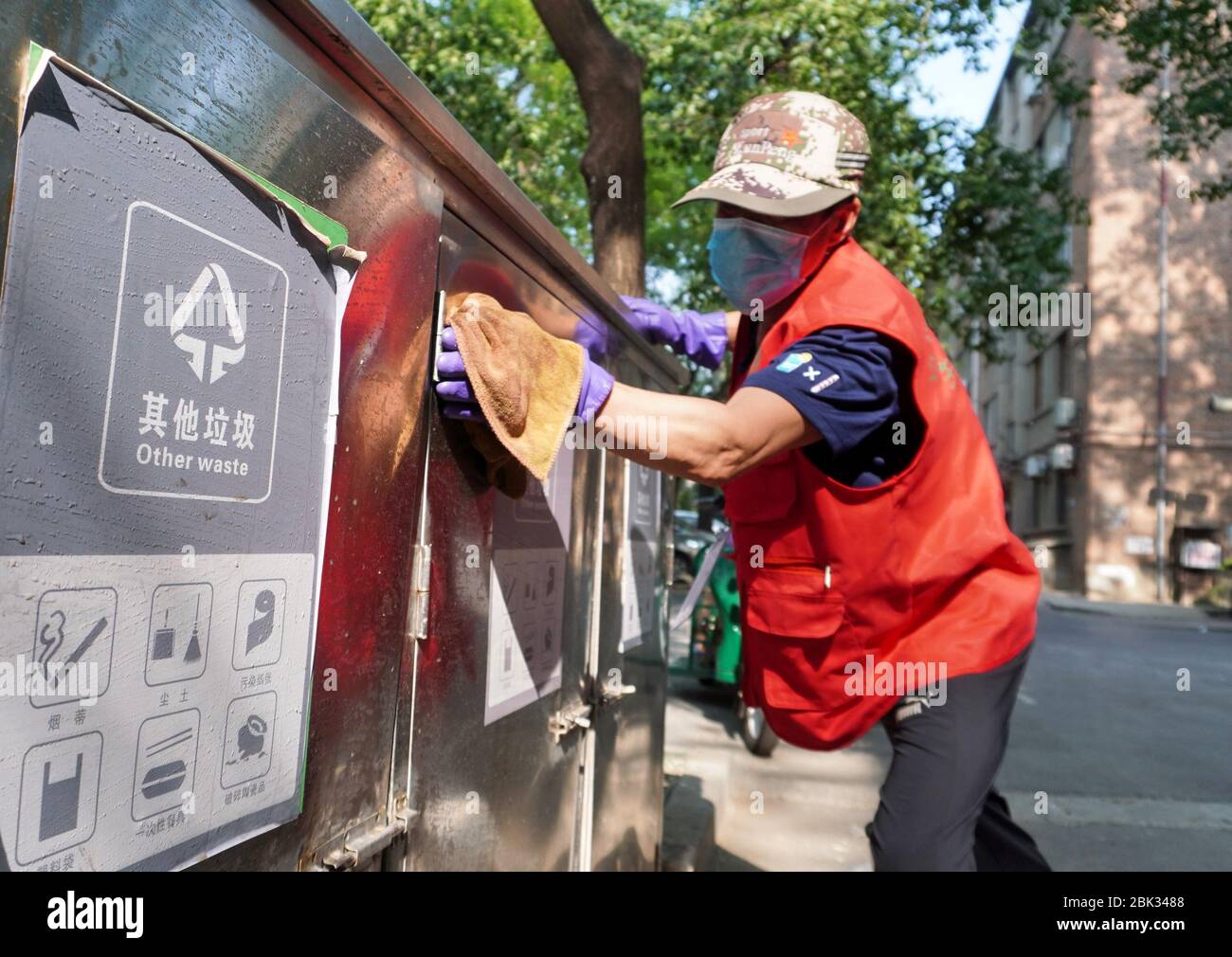 Beijing, China. 1st May, 2020. A sanitation worker cleans a garbage ...