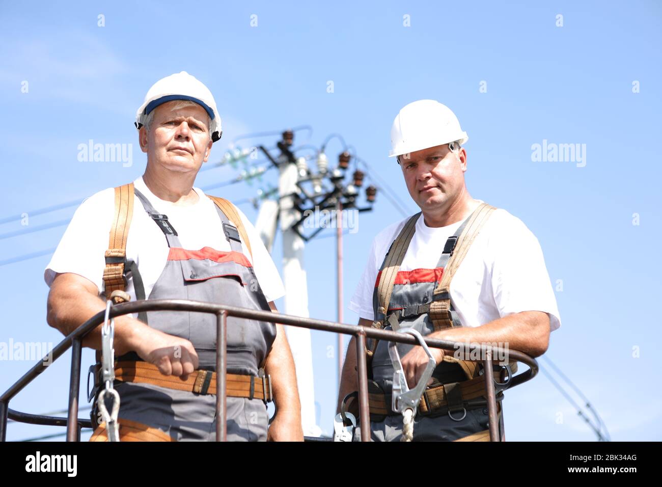 Two electrical workers on a lift. Engineers rise on a crane to repair a ...