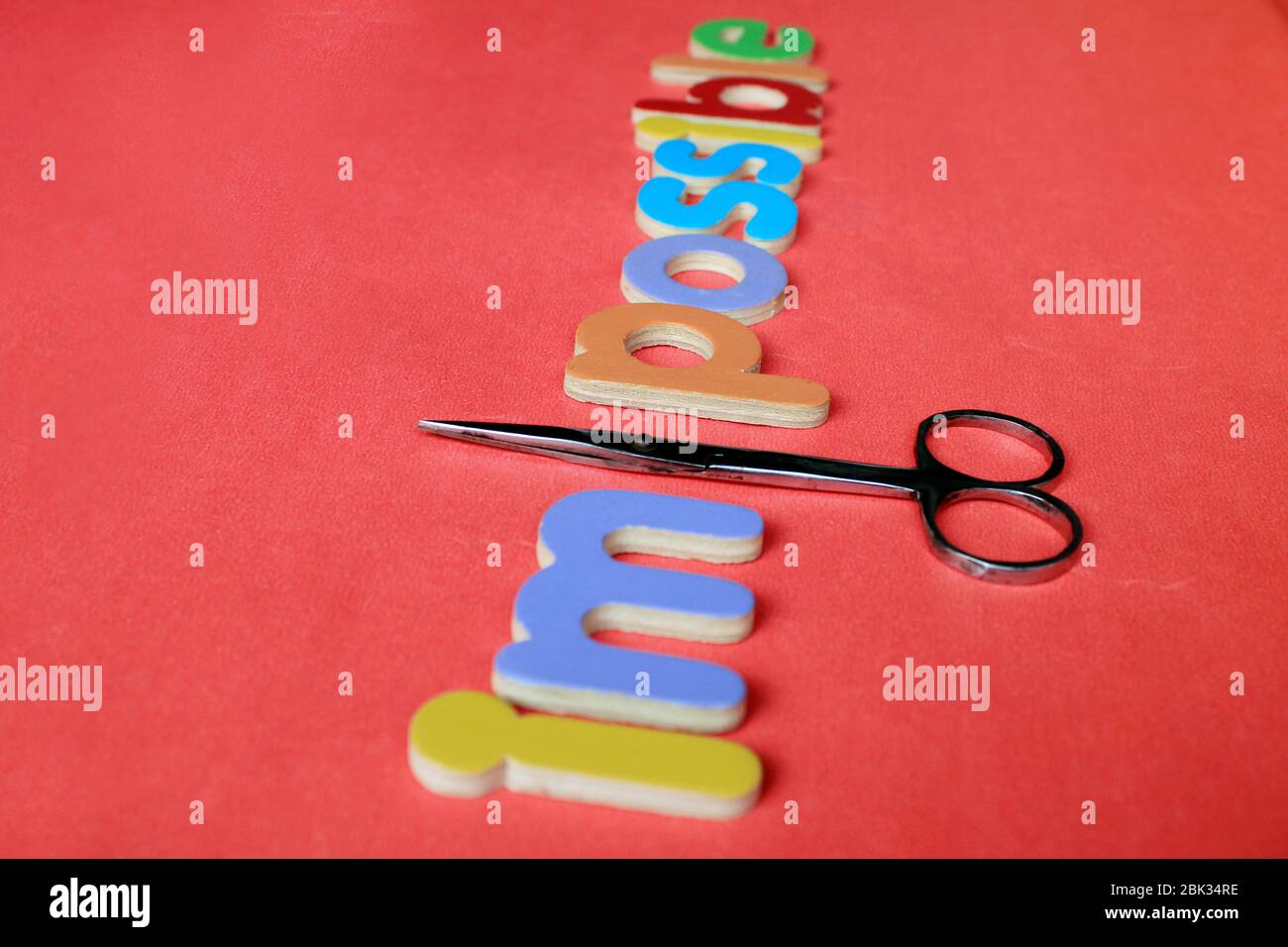 Self belief and positive concept, scissors cut off the word Impossible ...