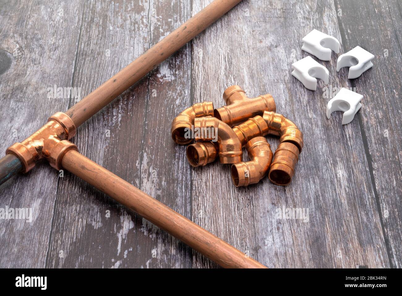 A plumbers copper tube background, with pipe clips Stock Photo - Alamy