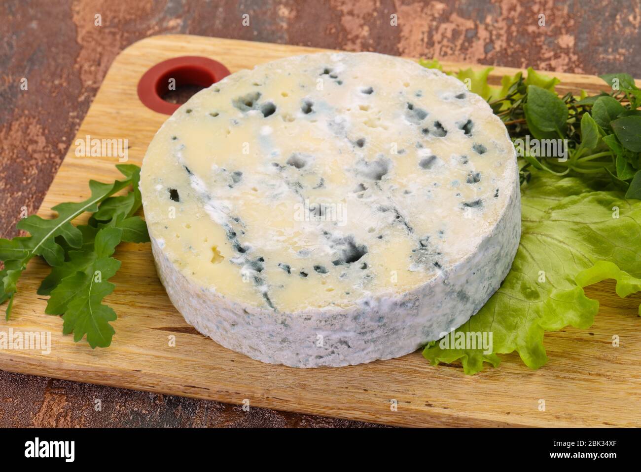 Round blue cheese with salad and basil Stock Photo - Alamy