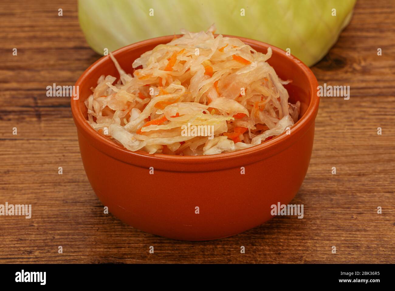 Pickled cabbage - sauerkraut in the bowl over wooden Stock Photo - Alamy
