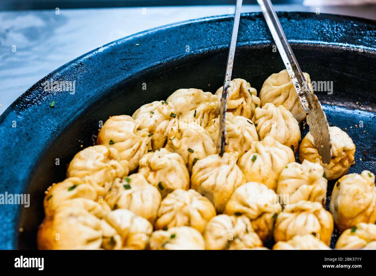 Shengjianbao in the heavy iron cooking skillet waiting for eaters at Da ...