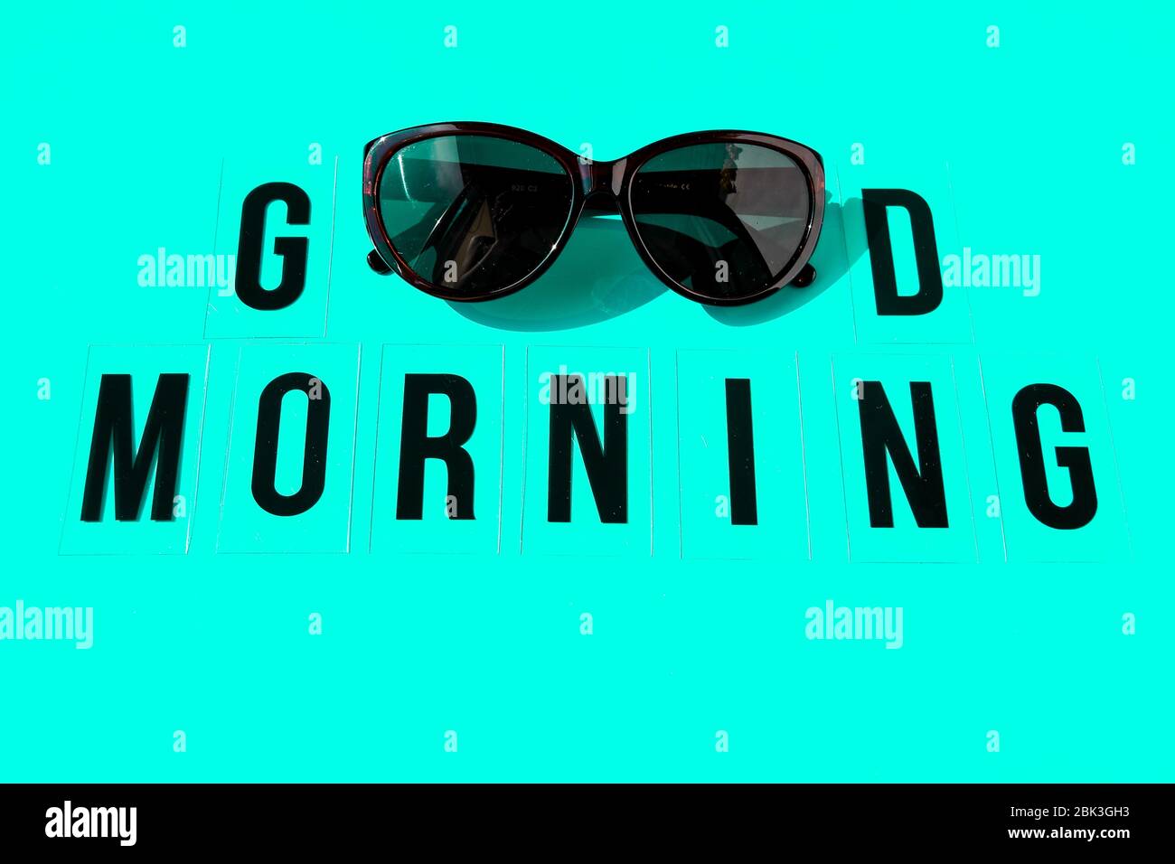 Sunglasses on Purple blue background and text GOOD MORNING. Top view ...
