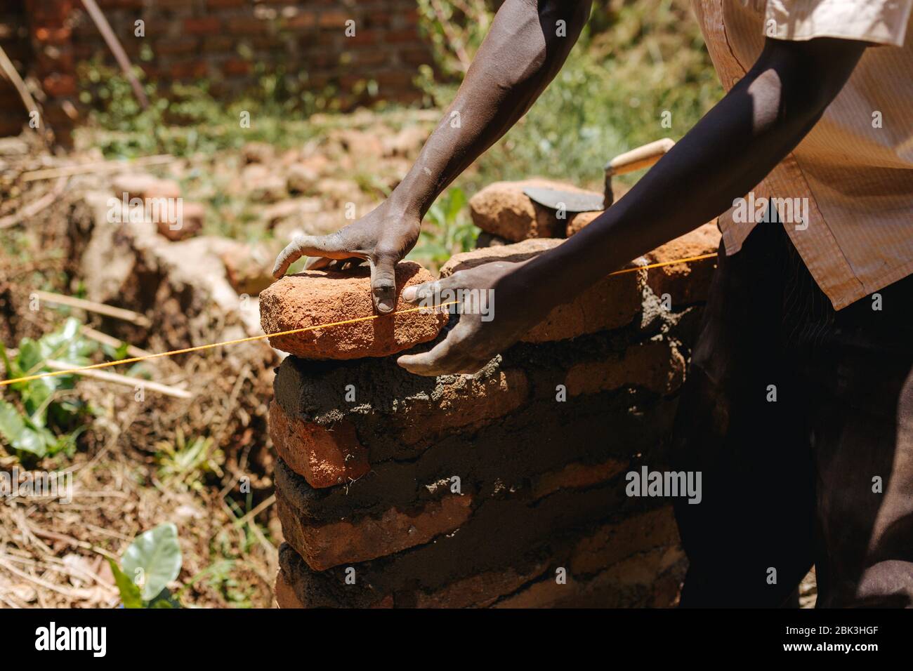 Man building a brick wall in Uganda, Africa Stock Photo - Alamy