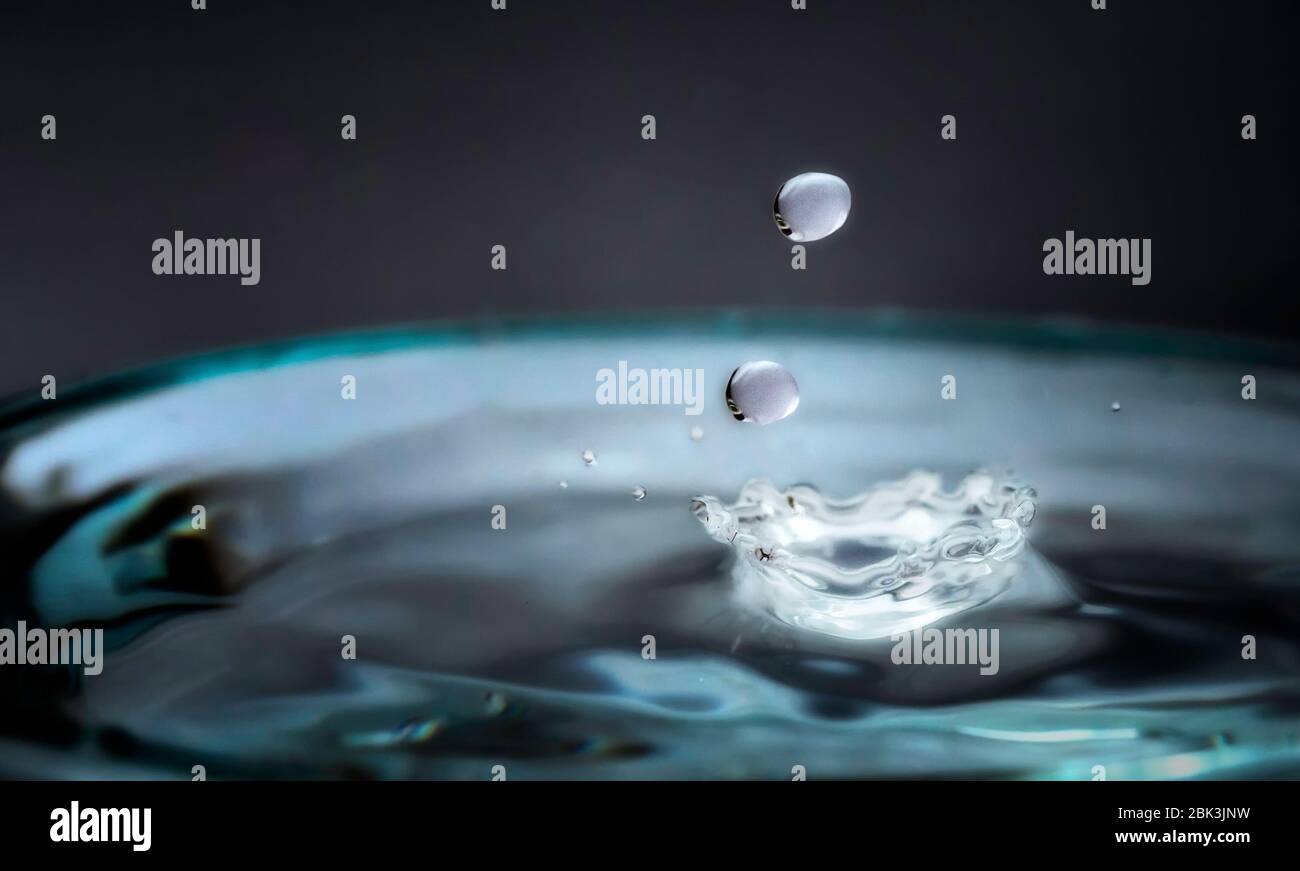 Water drops splash in a glass bowl of water below, United States, color ...