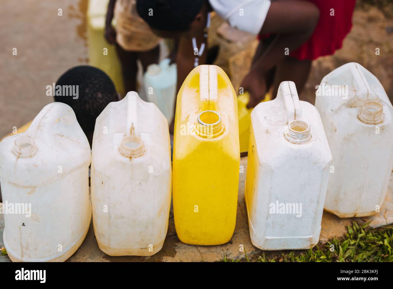 People getting water at a well with water cans Stock Photo - Alamy