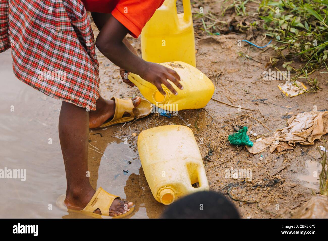 People getting water at a well with water cans Stock Photo - Alamy