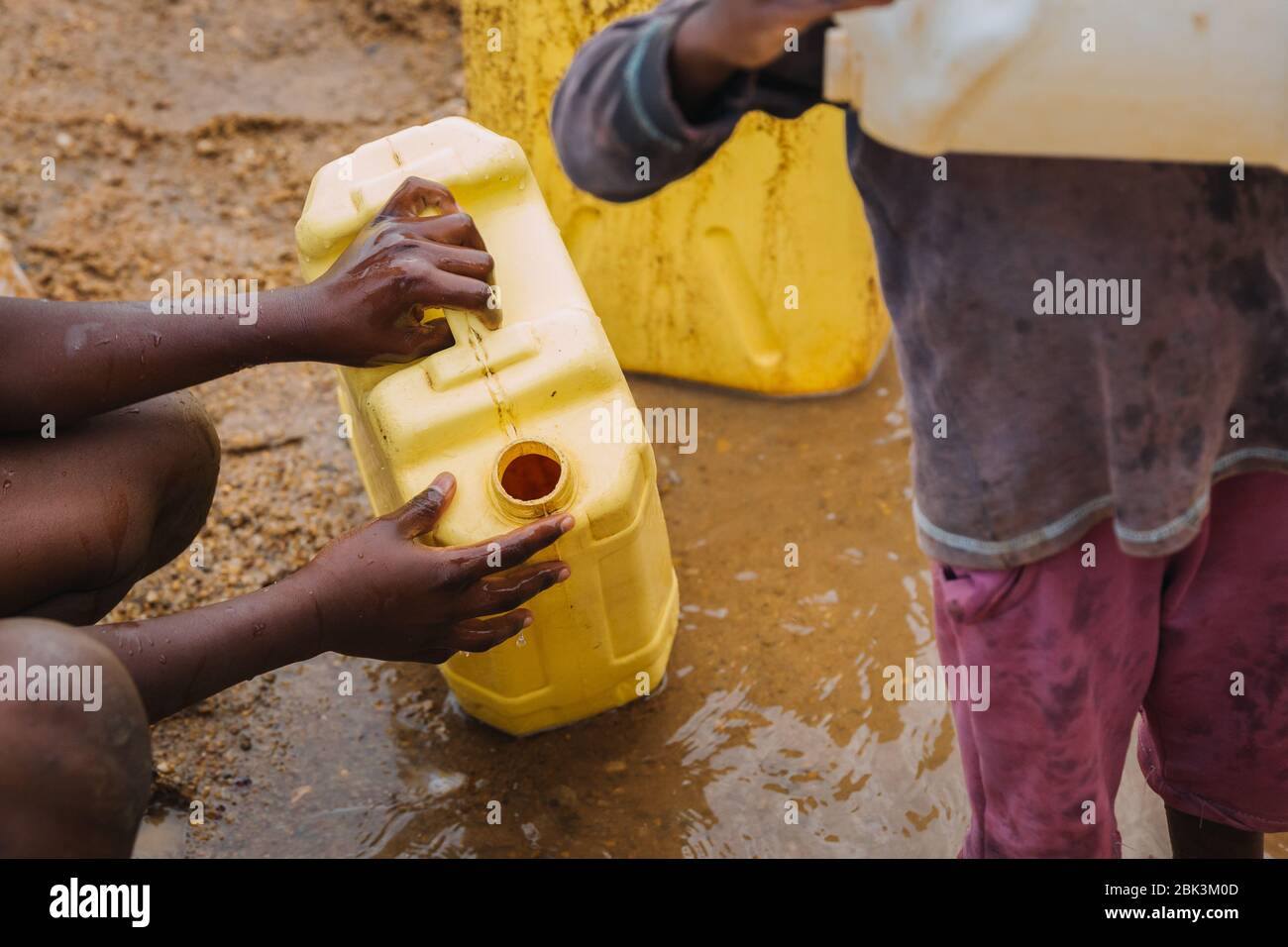 People getting water at a well with water cans Stock Photo - Alamy