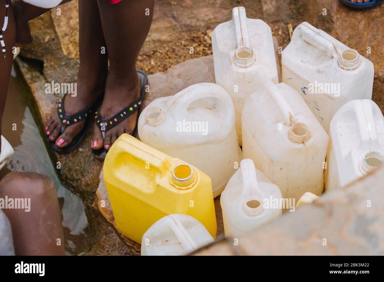 People getting water at a well with water cans Stock Photo - Alamy