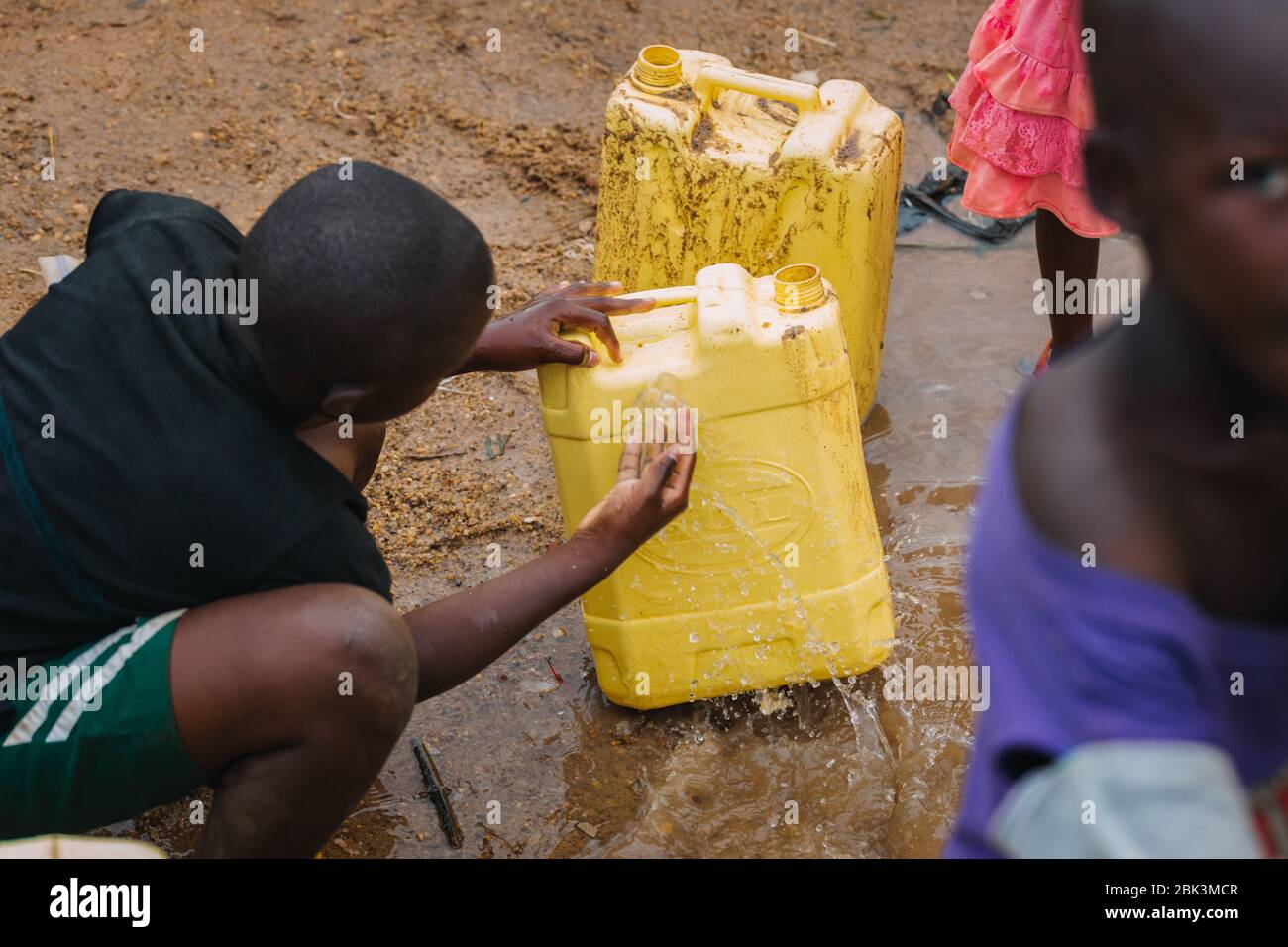 People getting water at a well with water cans Stock Photo - Alamy