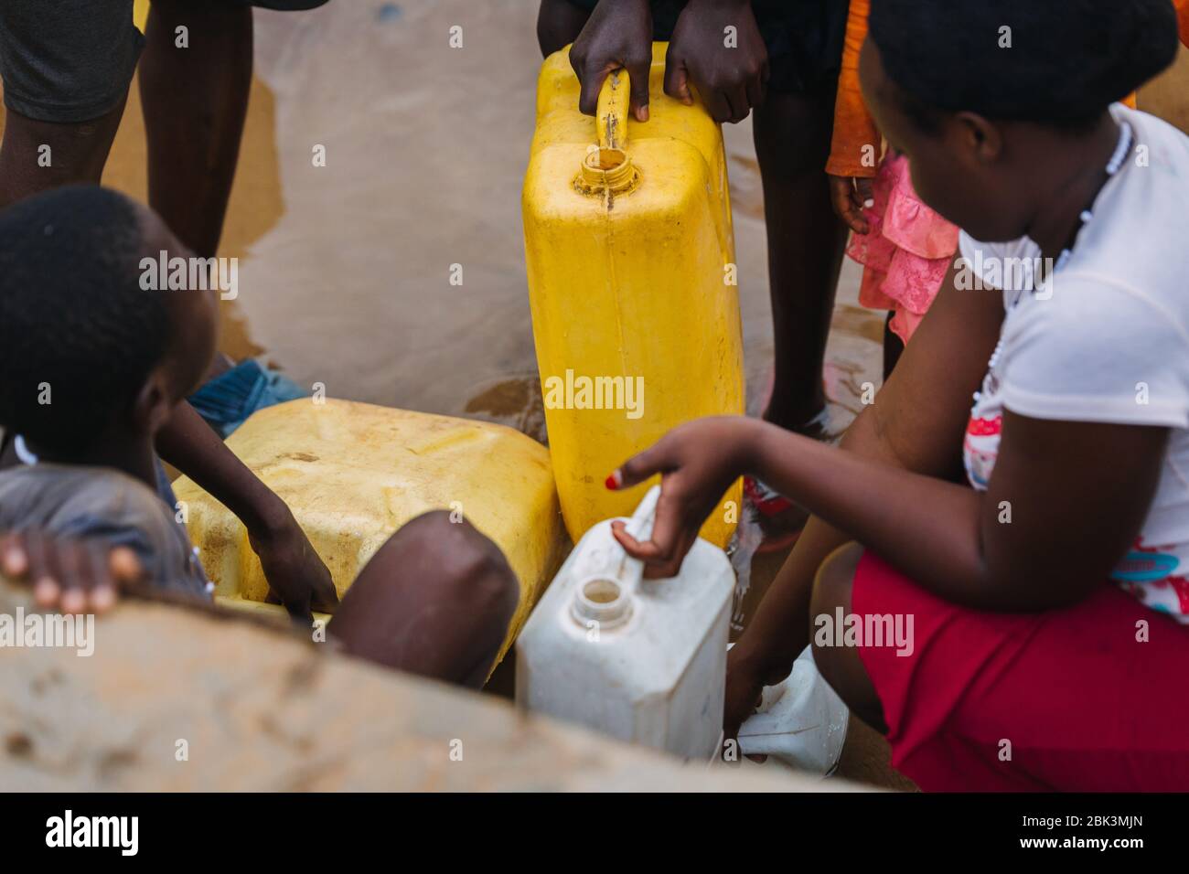 People getting water at a well with water cans Stock Photo - Alamy