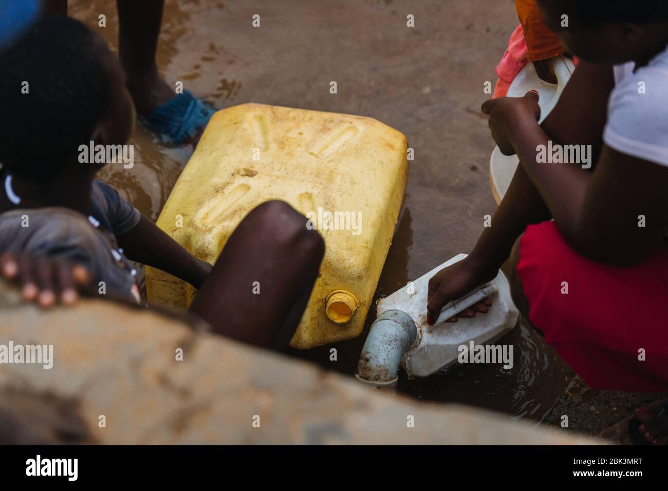 People getting water at a well with water cans Stock Photo - Alamy